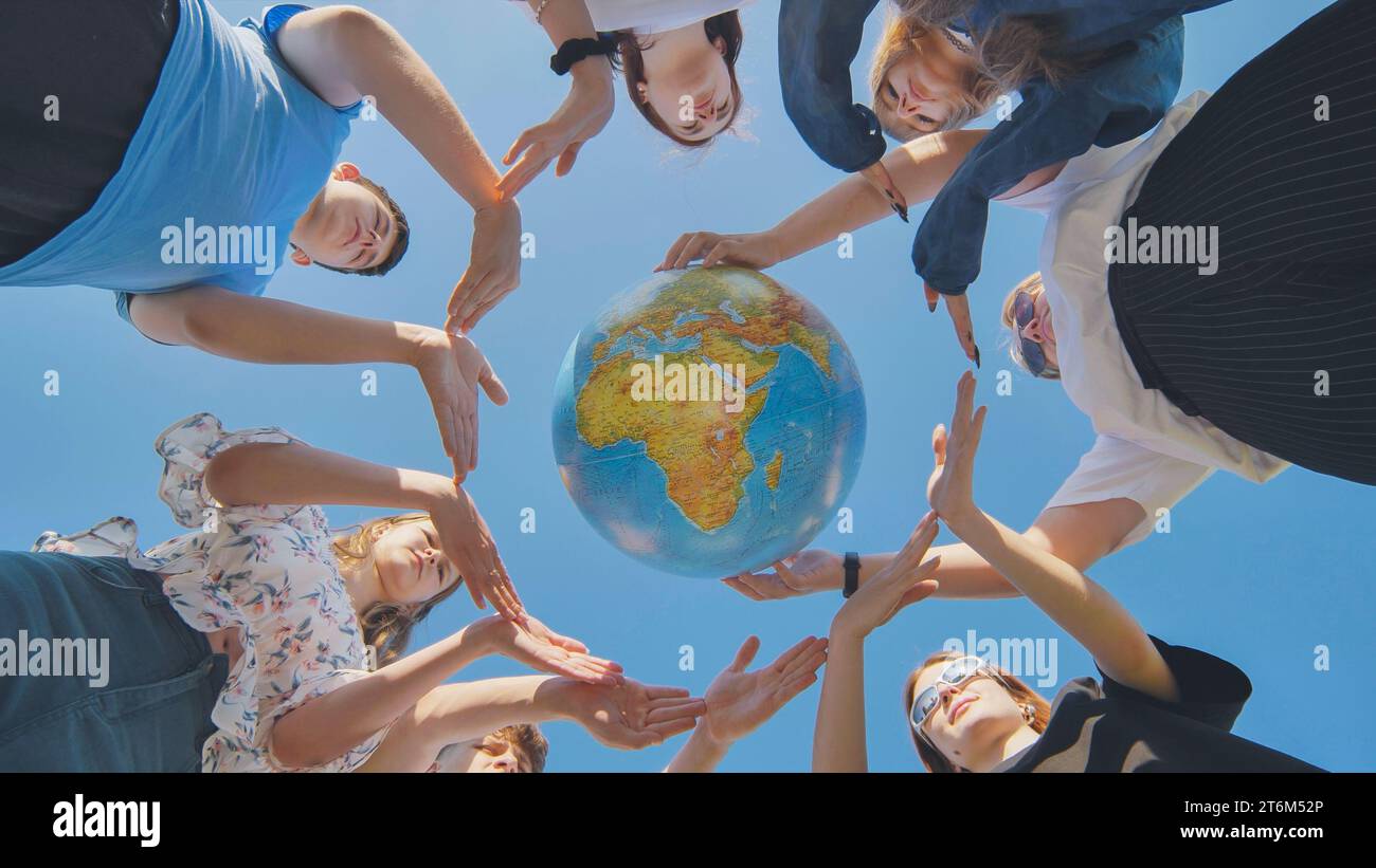 Young boys surround the globe of the world with their palms Stock Photo ...