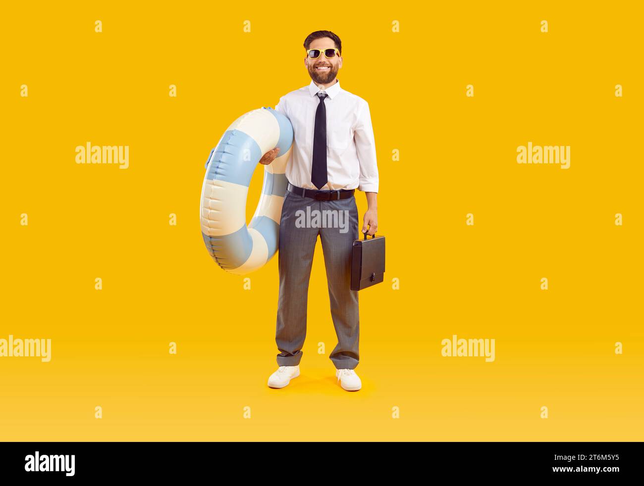 Happy man with inflatable ring and briefcase combines business trip and ...