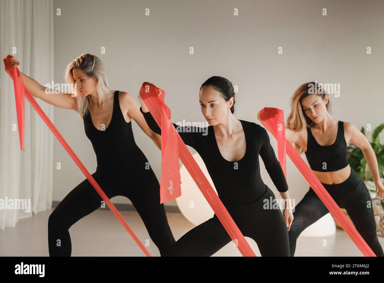 Girls in black are doing fitness with red ribbons indoors Stock Photo ...