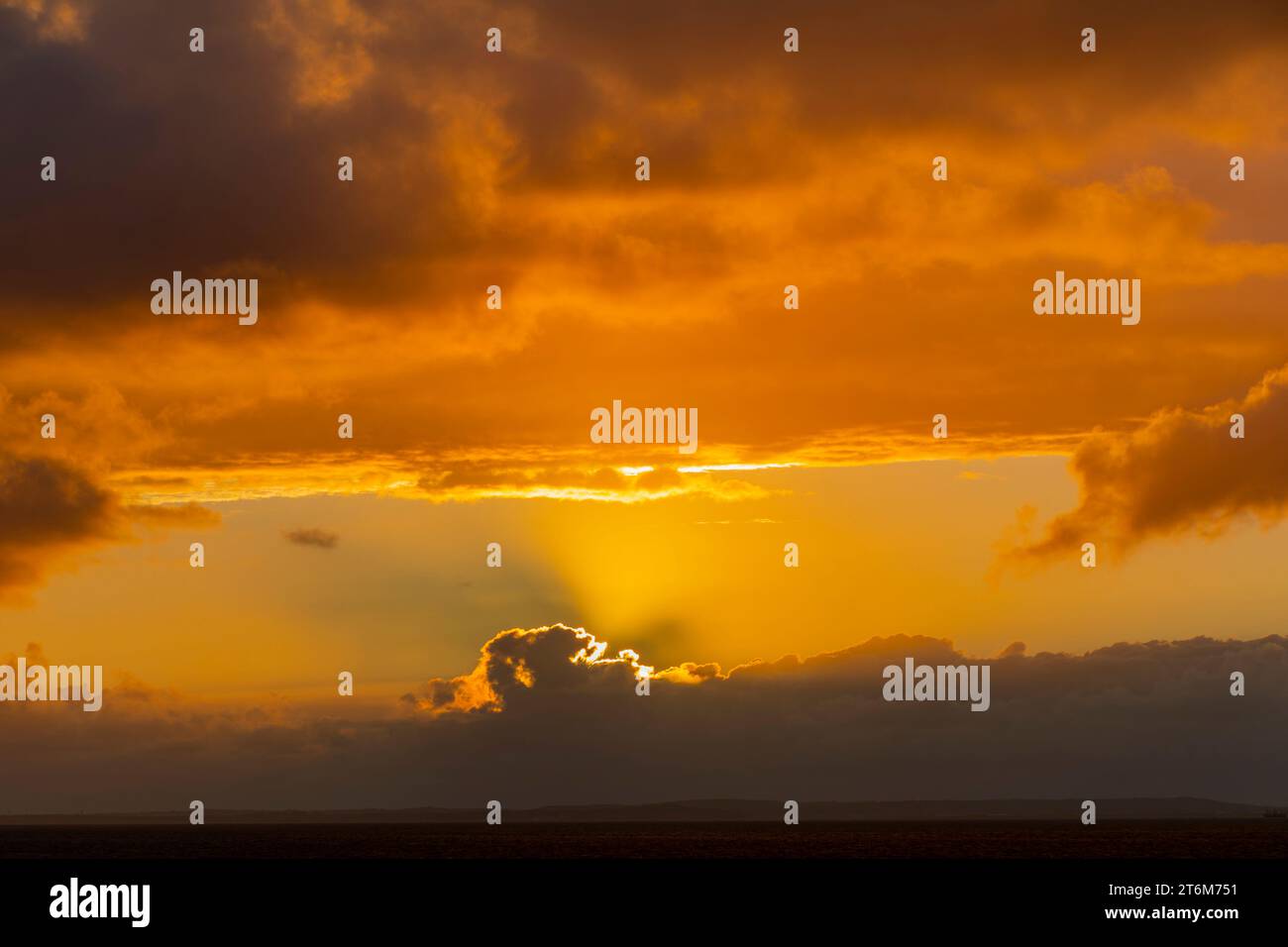 The sun disappearing behind some cloud cover Stock Photo - Alamy