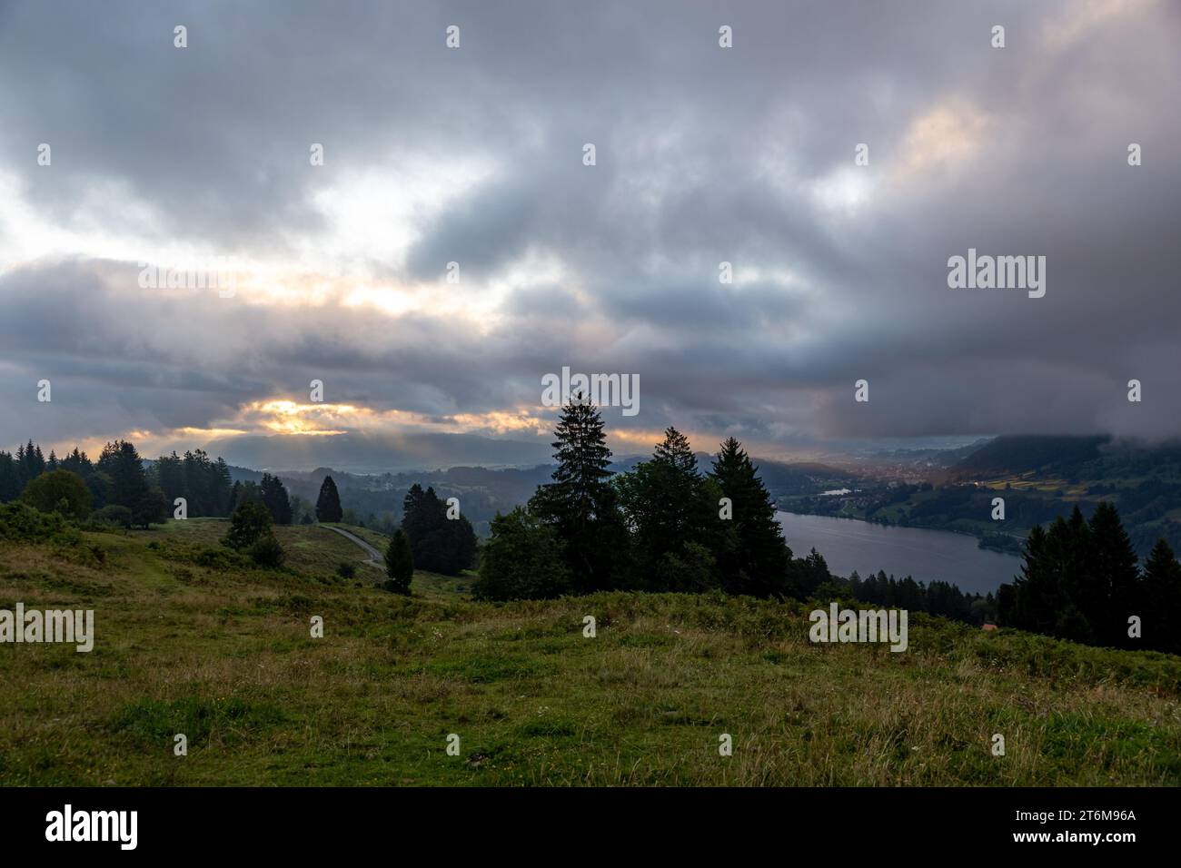 sun rays shining through clouds after sunrise at Alpsee in german alps ...