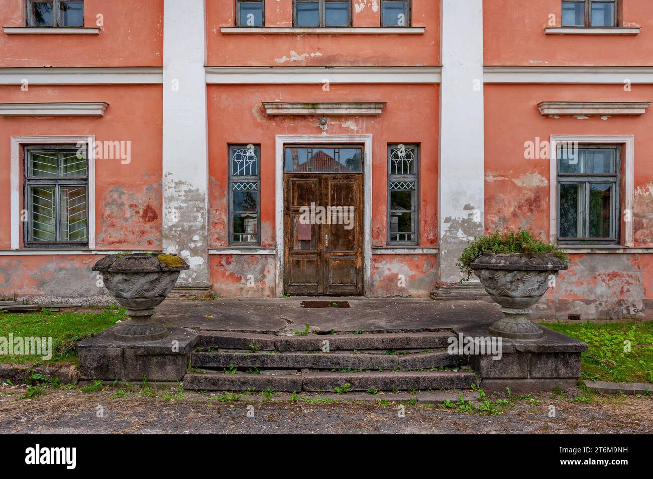 Old door and windows of red shabby house. Abandoned property of Stende ...