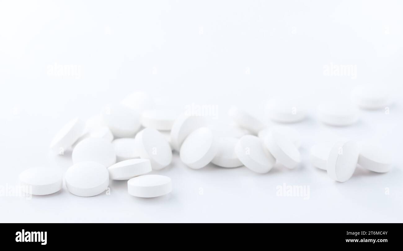 Round white pills, close-up on a white background. Medical and ...