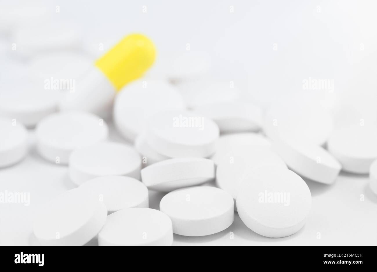 Health insurance concept, heap medical tablets and one yellow pill ...