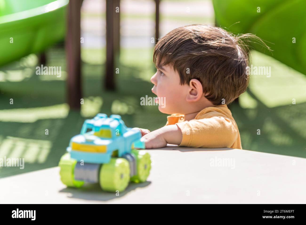 Little boy playing with a toy outdoors in playground Stock Photo - Alamy