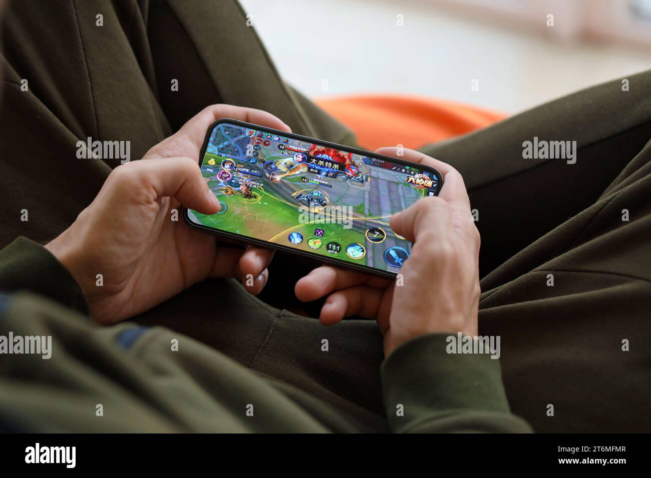 Honor of Kings mobile iOS game on iPhone 15 smartphone screen in male ...