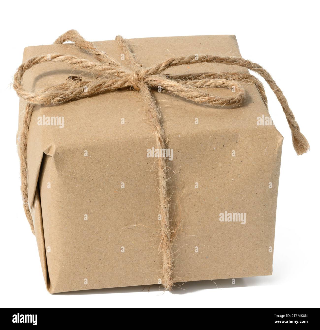 The box is packed in brown craft paper and tied with a rope on a white ...