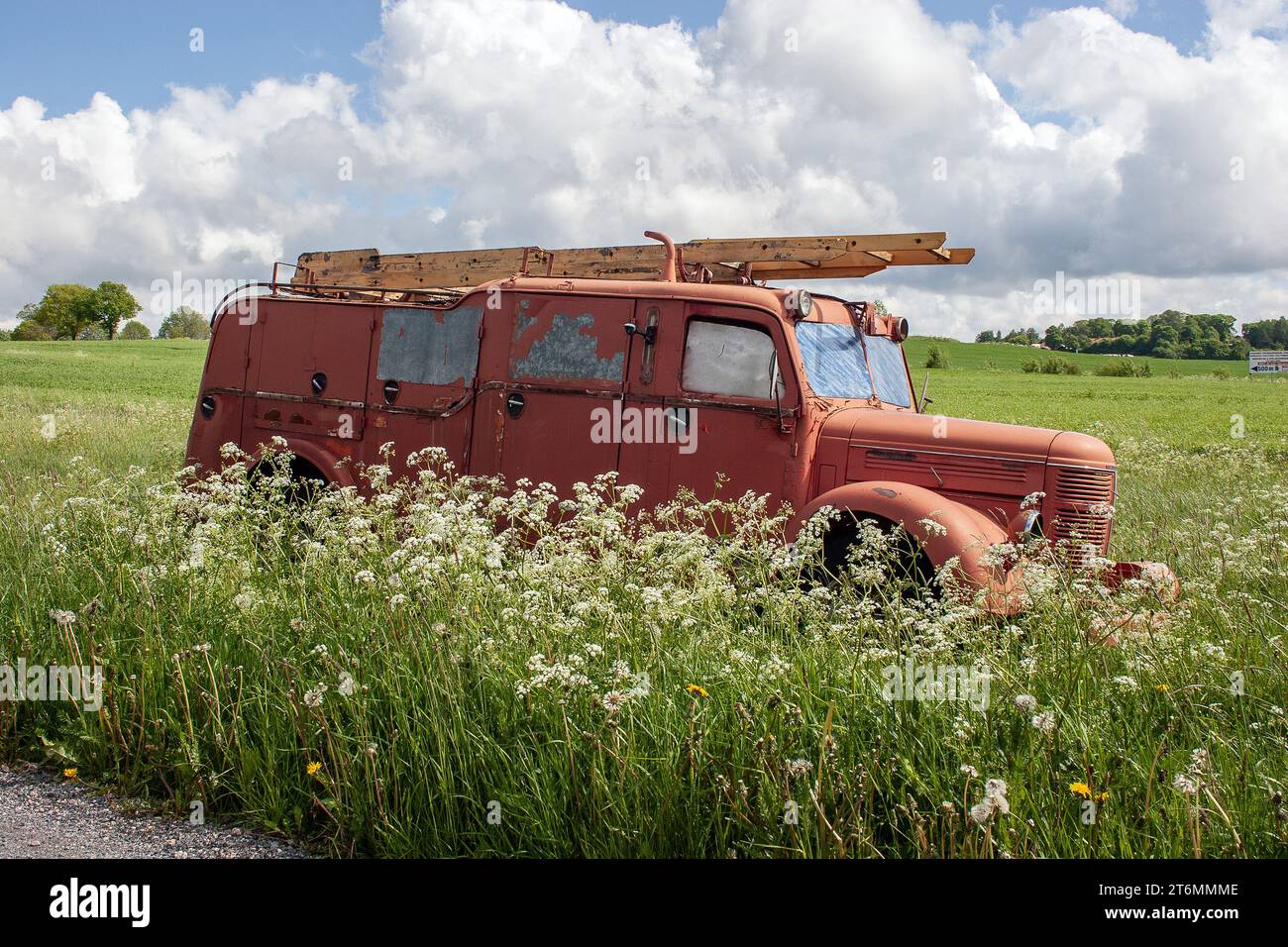 a red old fire engine stands abandoned in a meadow Stock Photo - Alamy