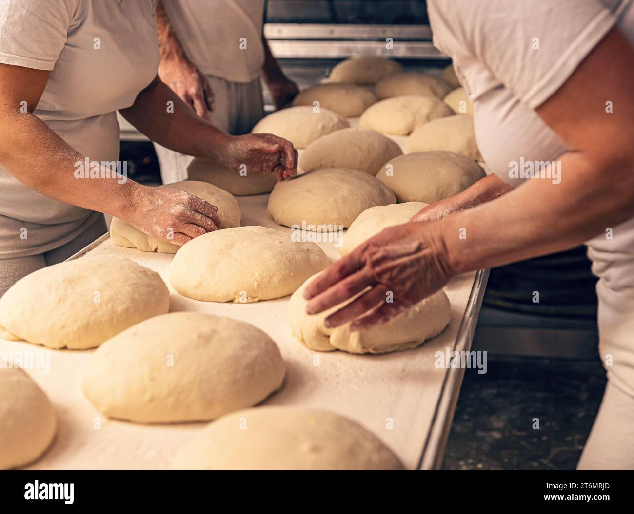 Bakers in the workplace in the bakery forming bread dough Stock Photo ...