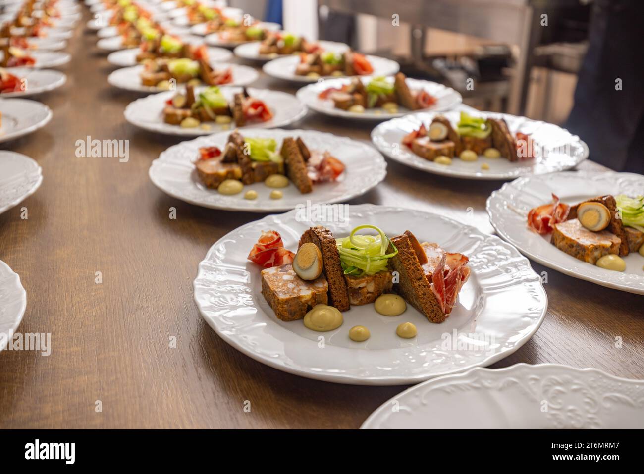 Multiple plates of beautifully presented food on restaurant kitchen ...