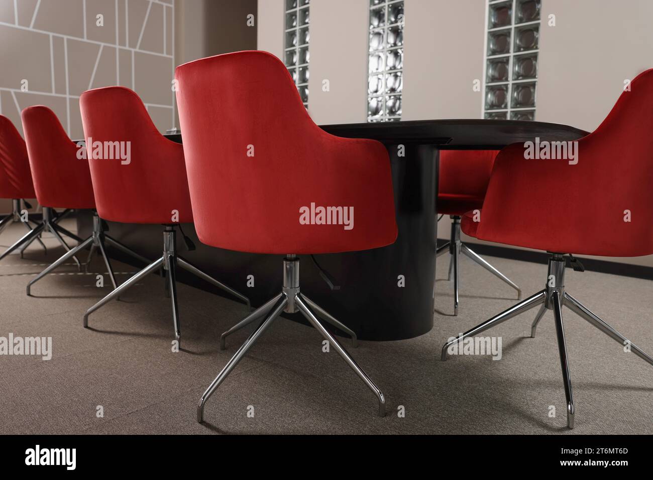 Stylish red office chairs and large table in empty conference room ...