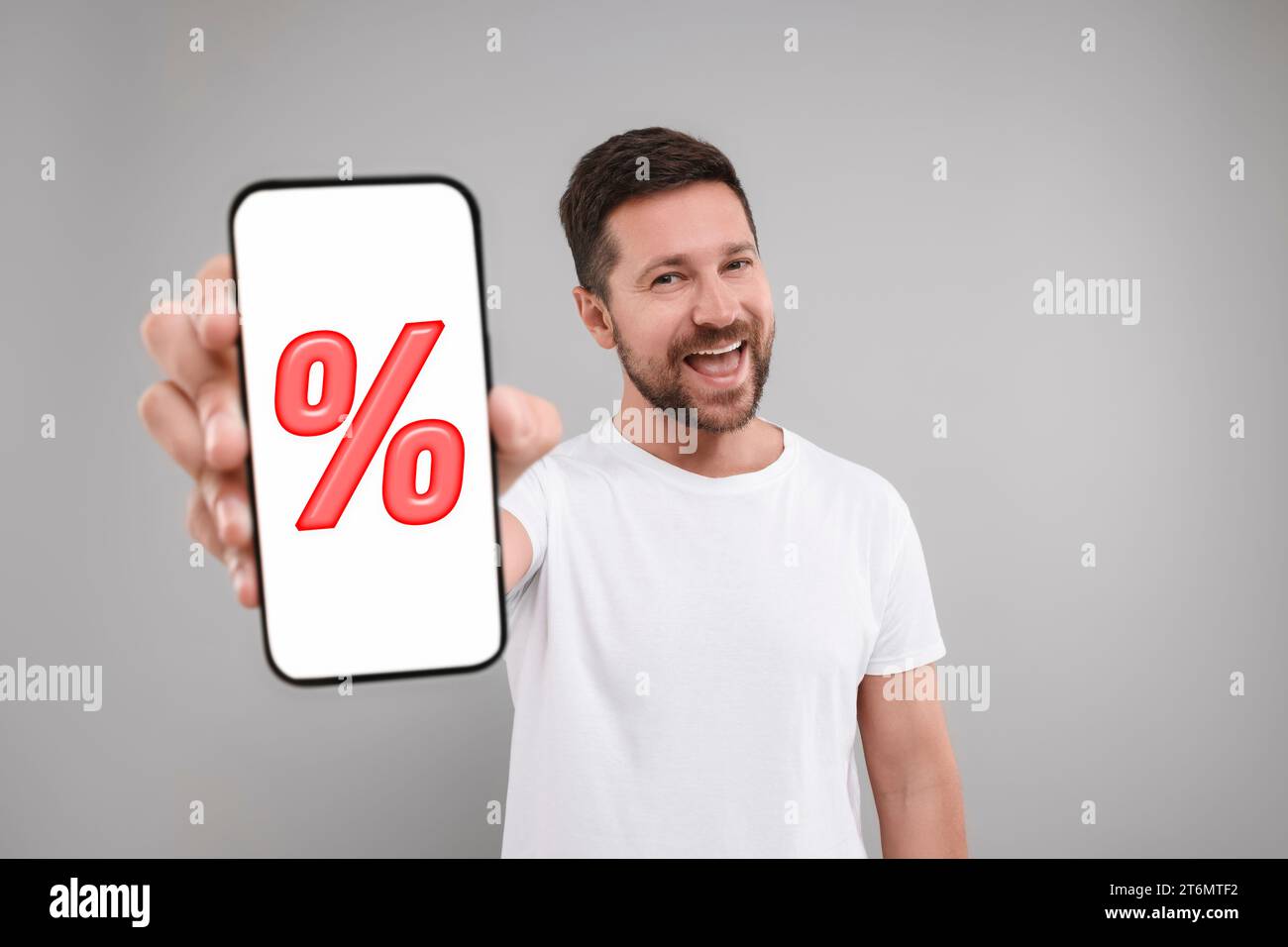 Discount, offer, sale. Man showing mobile phone with percent sign on ...