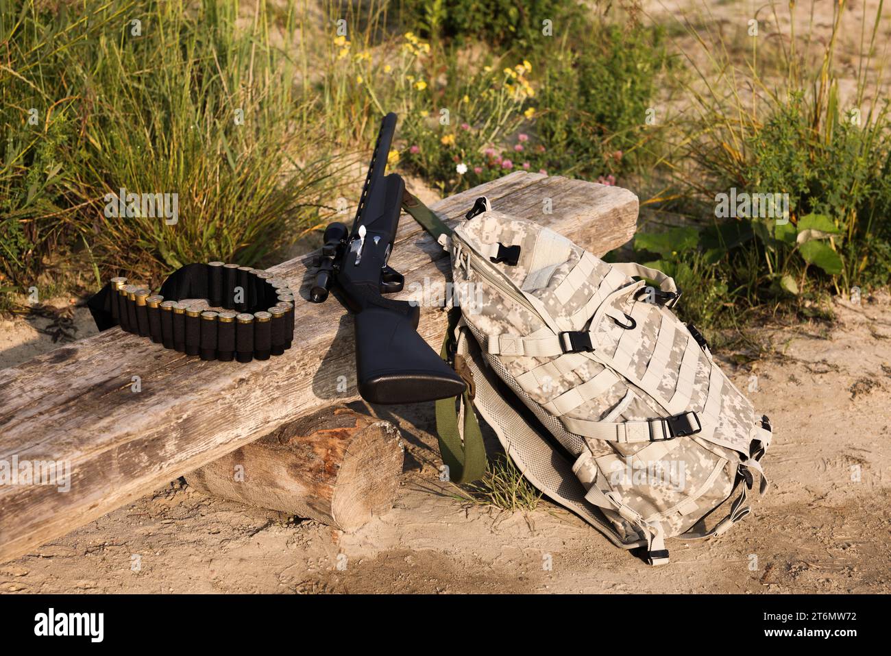 Hunting rifle, backpack and cartridges on wooden bench outdoors Stock ...