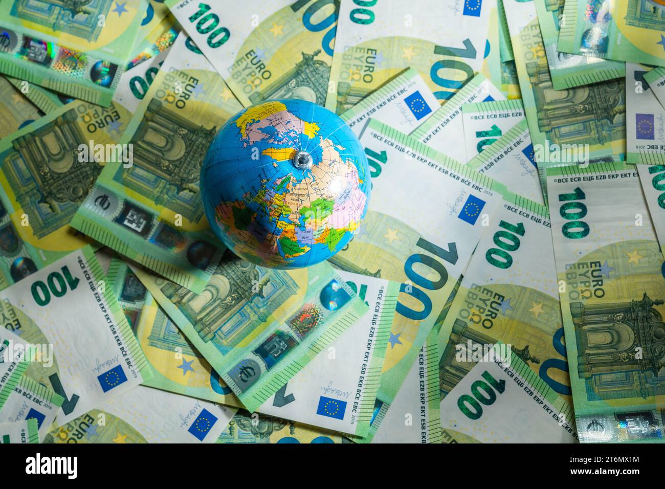 A little round globus viewed from above over many money bills, 100 euro ...