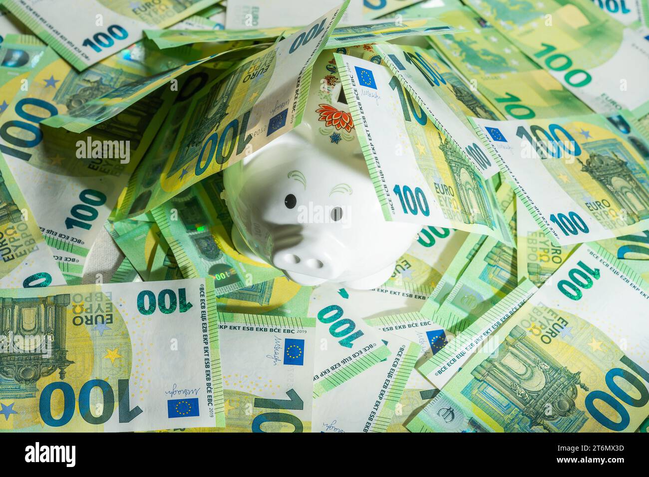 Money pig on the background of money bills of 100 euros covered with ...