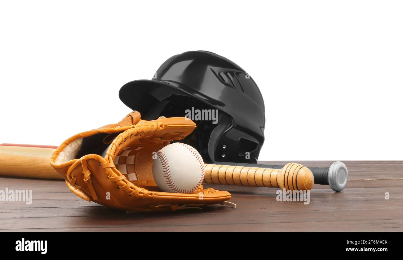Baseball glove, bats, ball and batting helmet on wooden table against ...