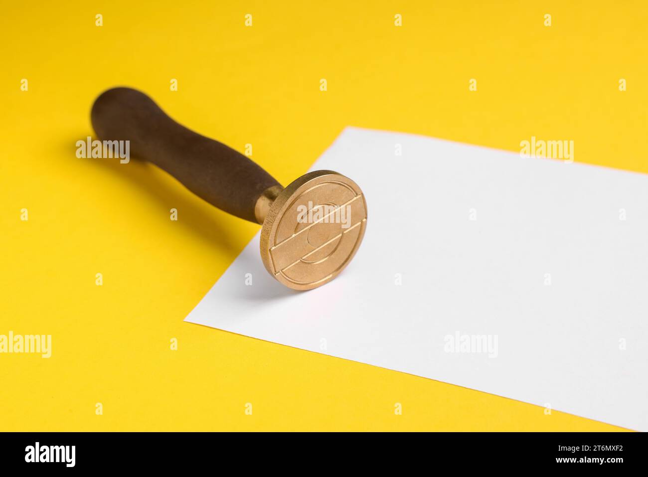 One stamp tool and sheet of paper on yellow background, closeup Stock ...