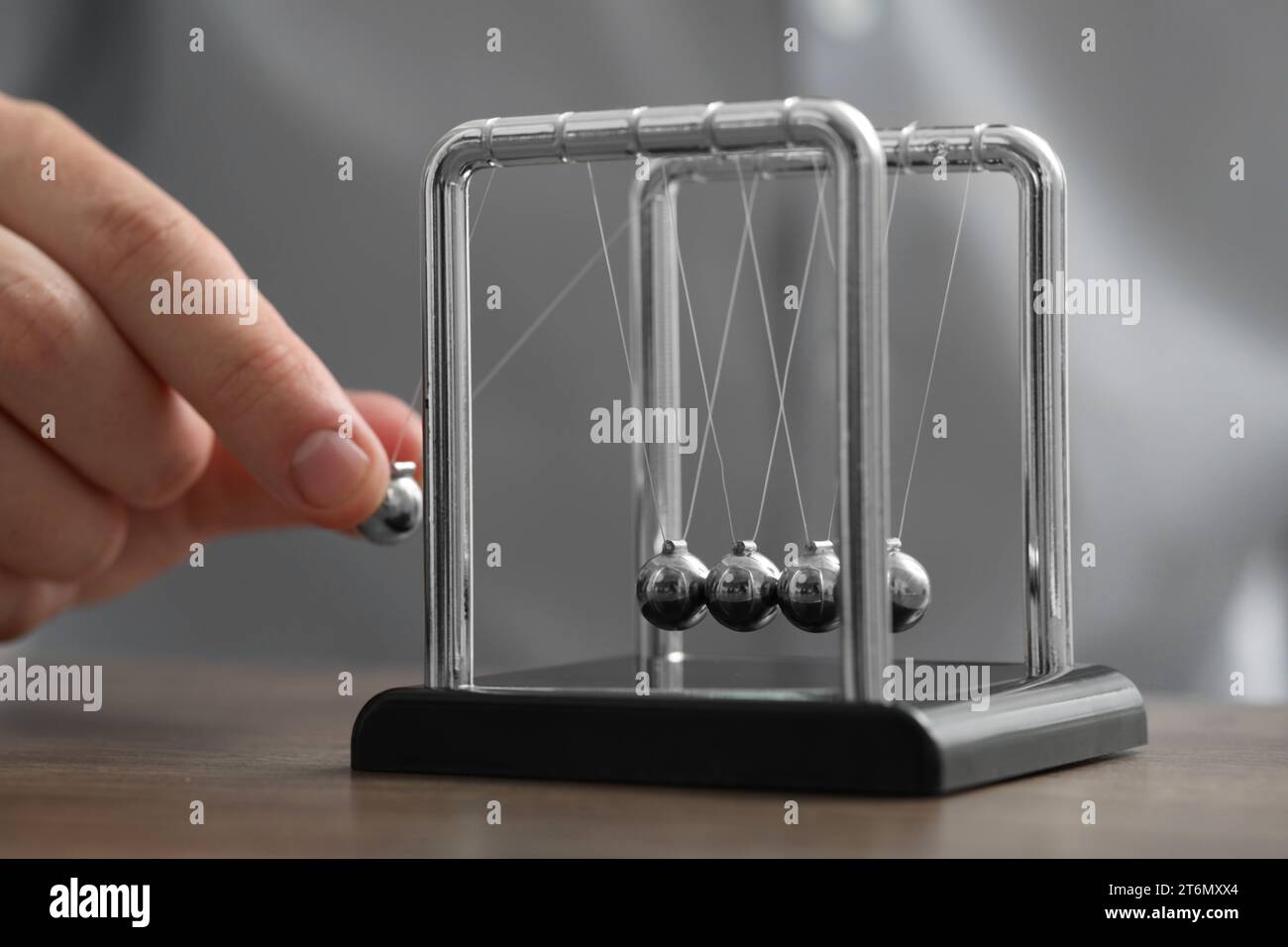 Newton's cradle and hand hi-res stock photography and images - Alamy
