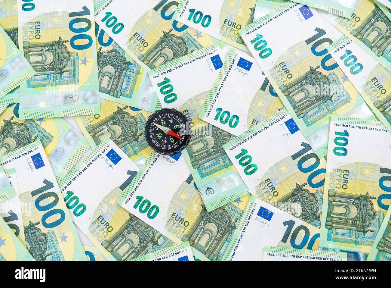 A little compass shown from above on many 100 euro money bills, making ...