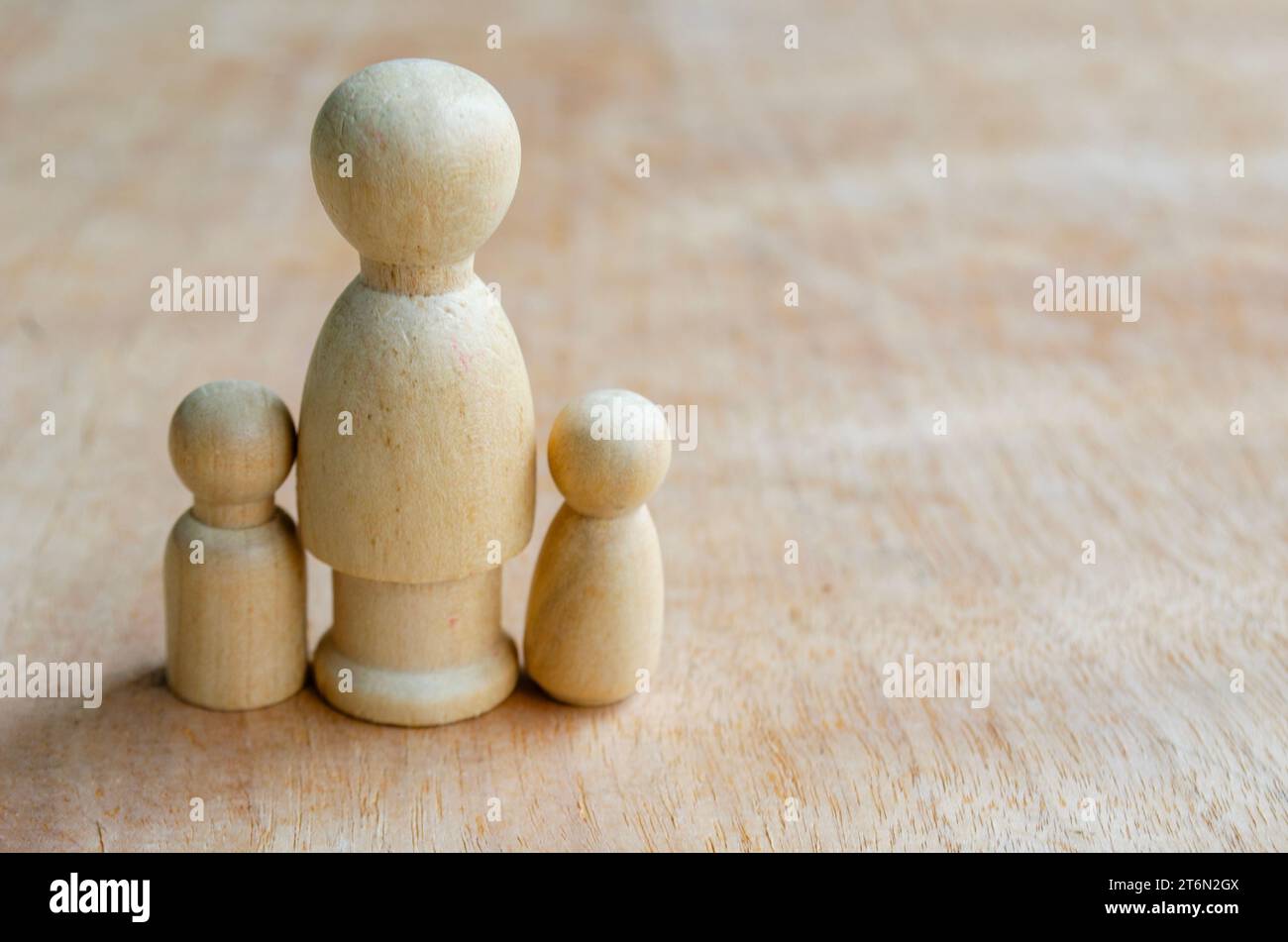 Wooden figure represent a mother with two children. Family concept ...