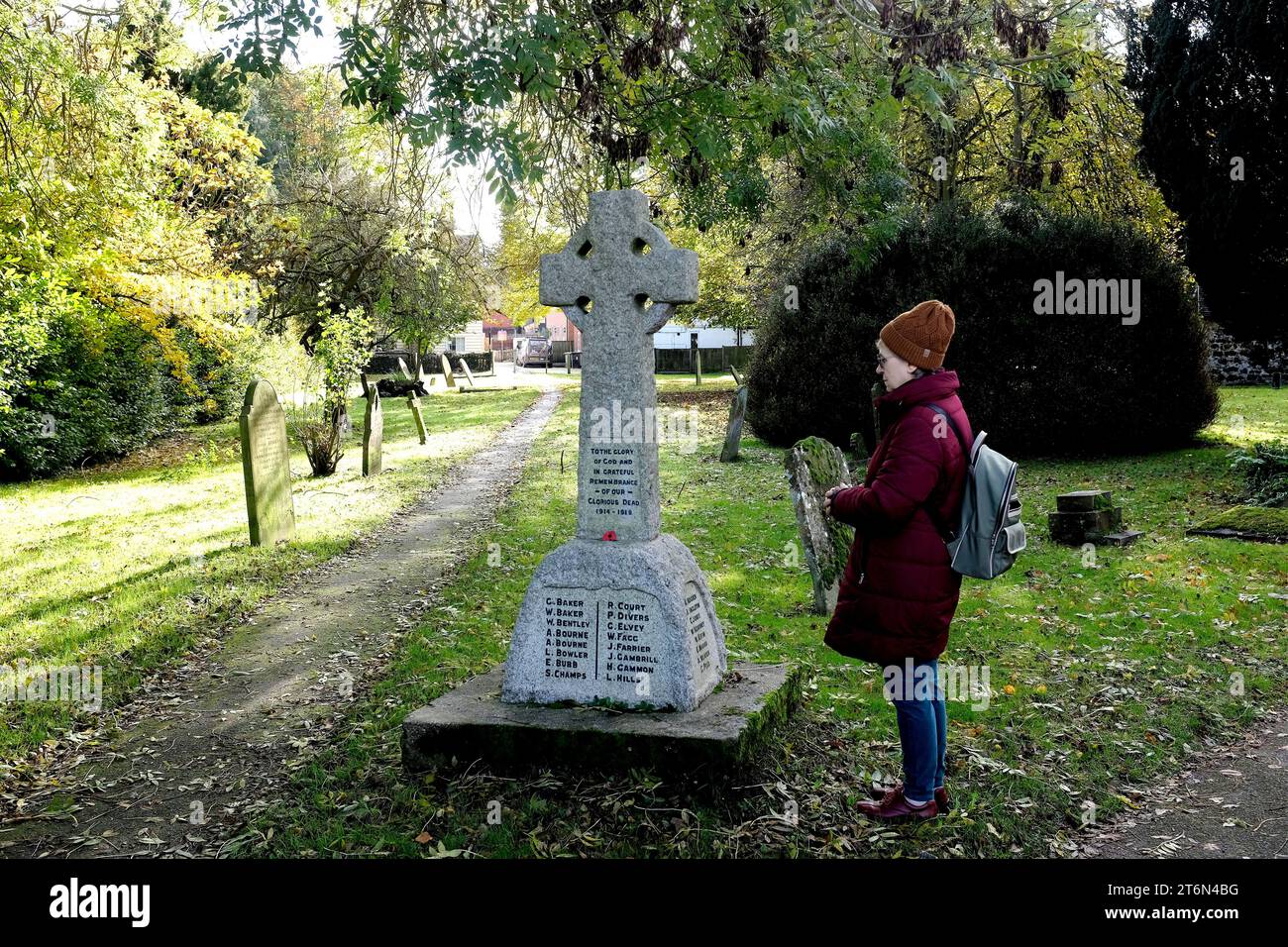 woman in 2 minutes silence standing beside a memorial cross for poppy ...