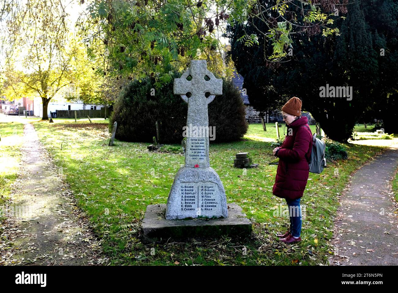 woman in 2 minutes silence standing beside a memorial cross for poppy ...