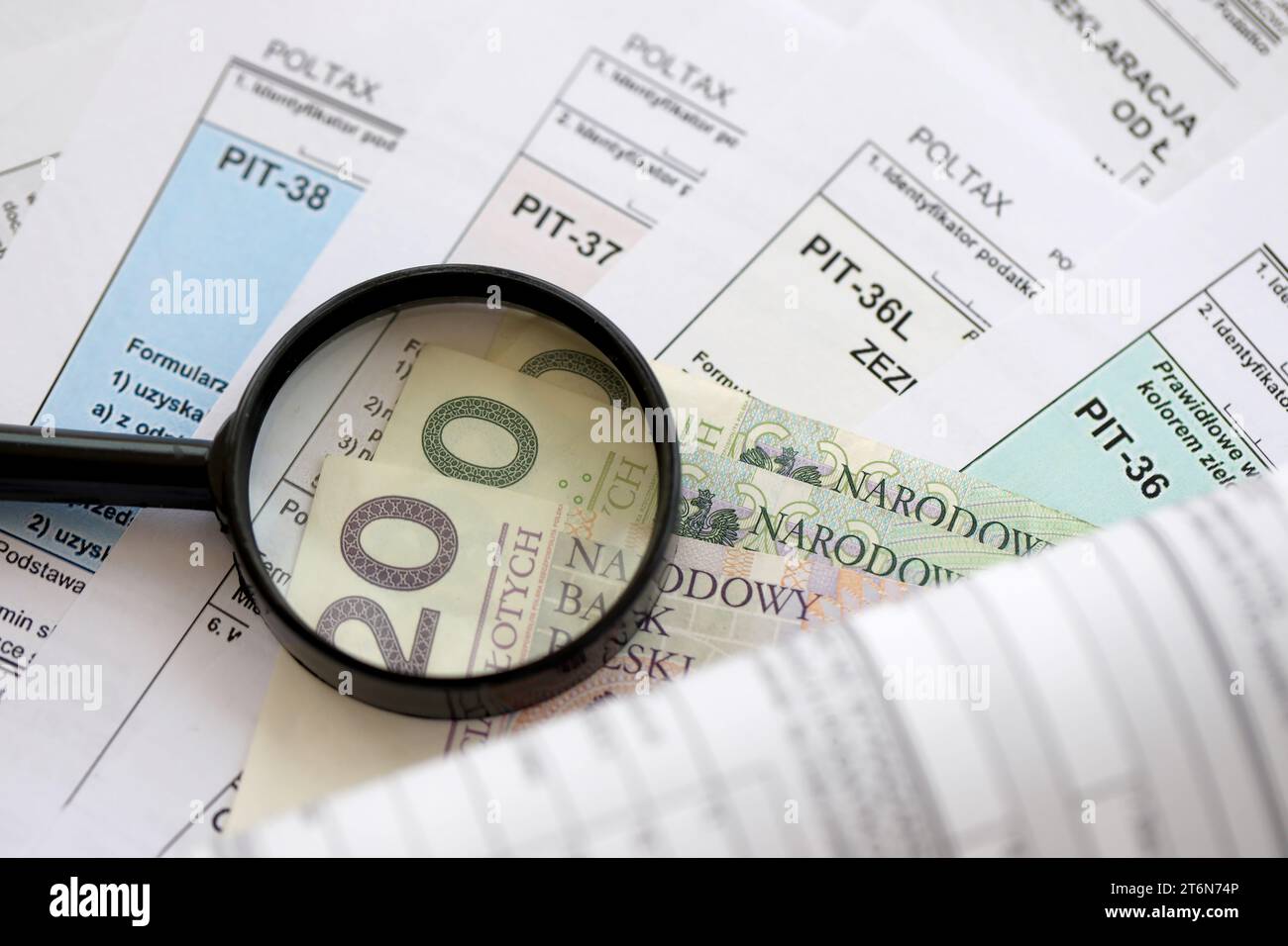 Polish zloty money and magnifying glass on big amount of polish tax ...