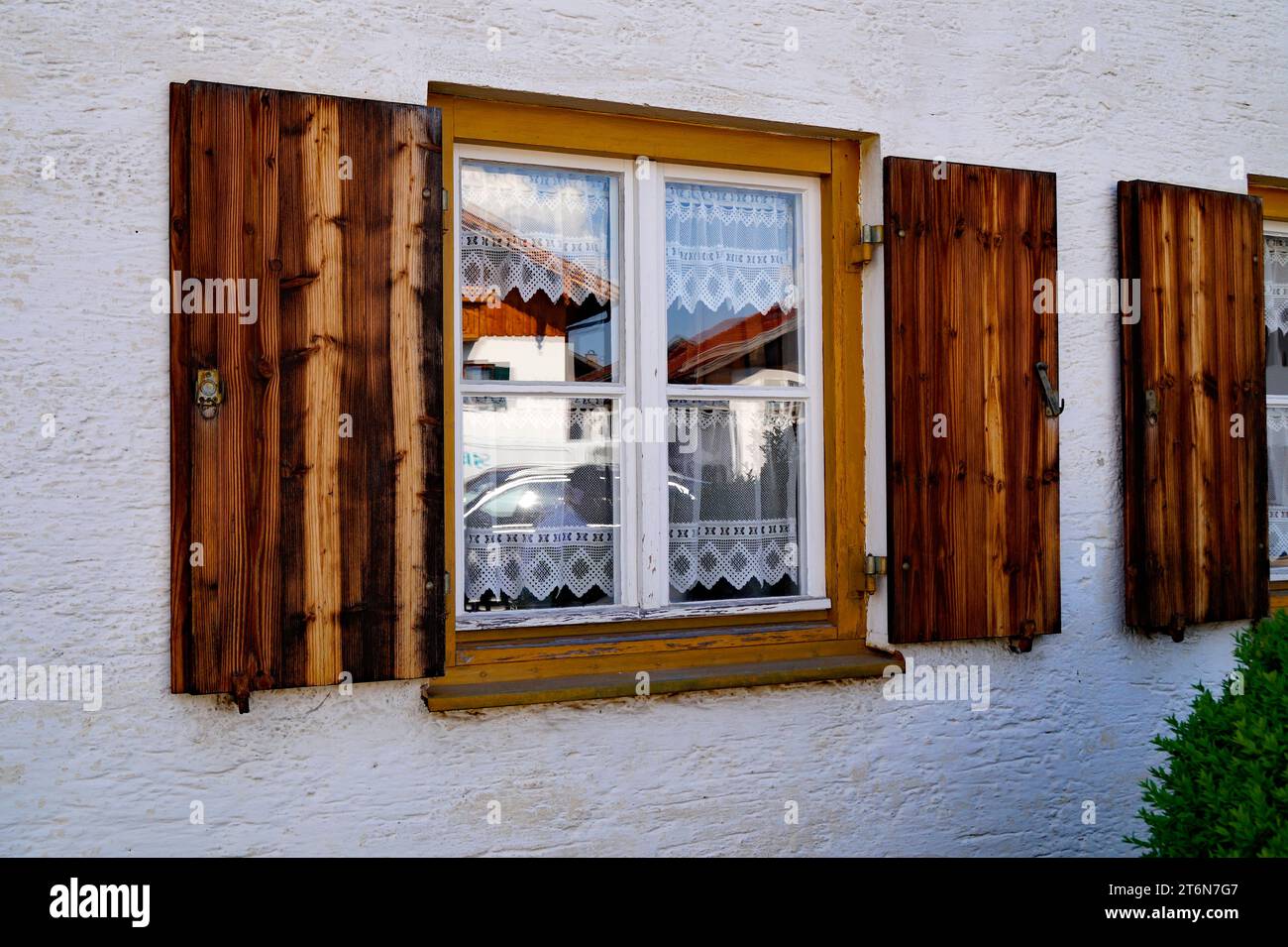 a traditional Bavarian rustic window with cute white lacy drapes and ...
