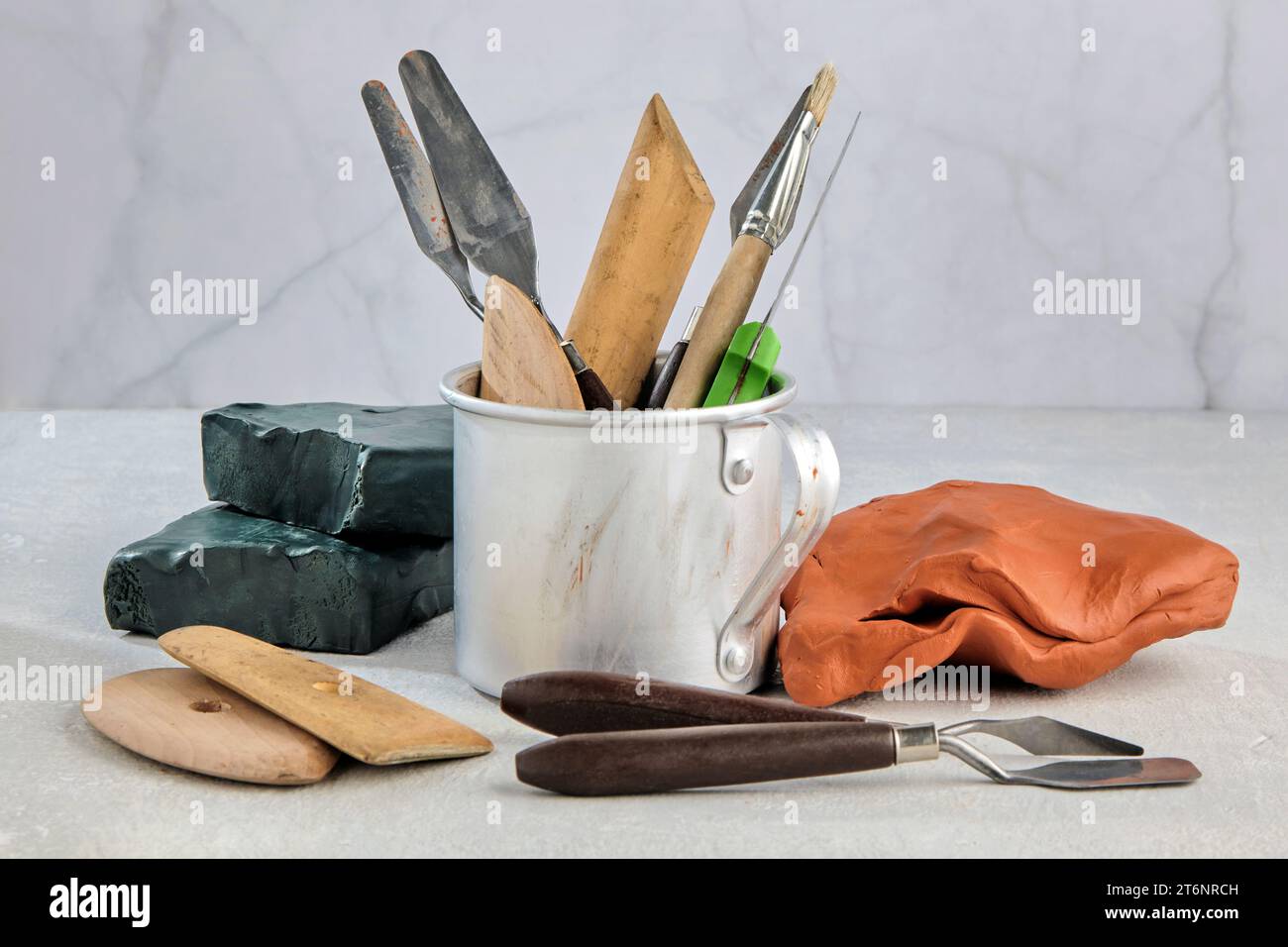 Modeling tools from plasticine and clay in a metal mug and pieces of ...
