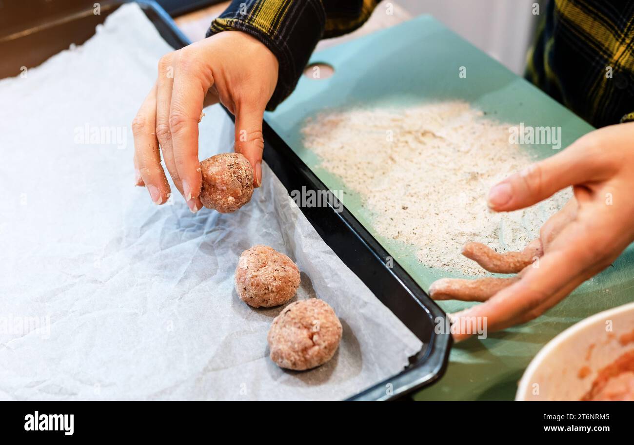 Cooking handmade meatballs. Meatball in female hands while cooking ...