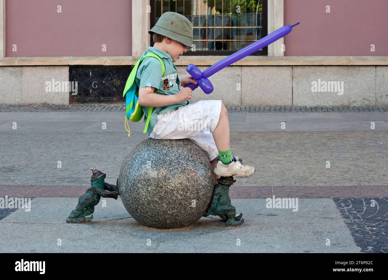 Child at sculpture of Ball-pushing and lifting Sisyphus dwarfs near ...