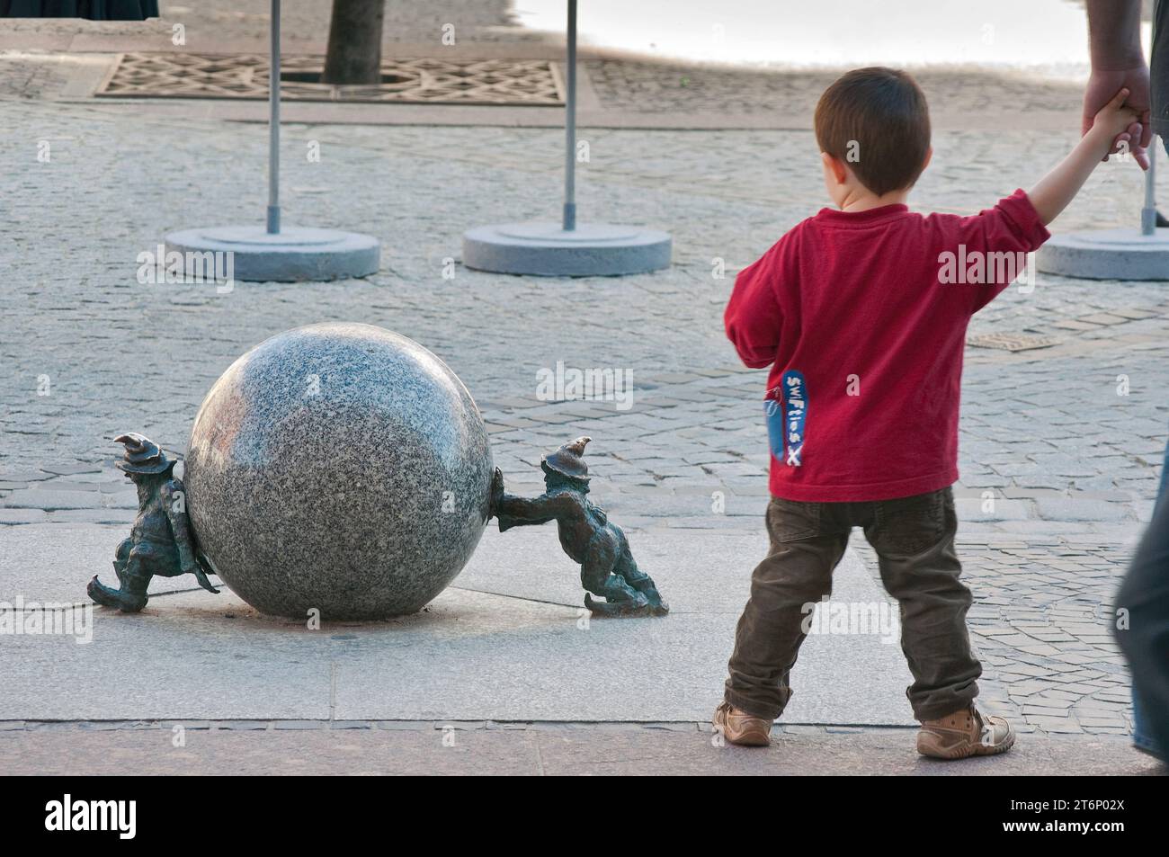 Child at sculpture of Ball-pushing and lifting Sisyphus dwarfs near ...