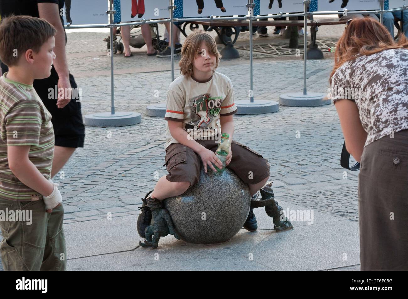 Mom taking pictures of child at sculpture of Ball-pushing and lifting ...