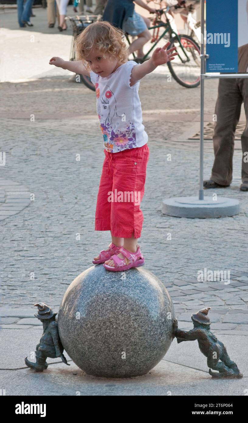 Child balancing at sculpture of Ball-pushing and lifting Sisyphus ...
