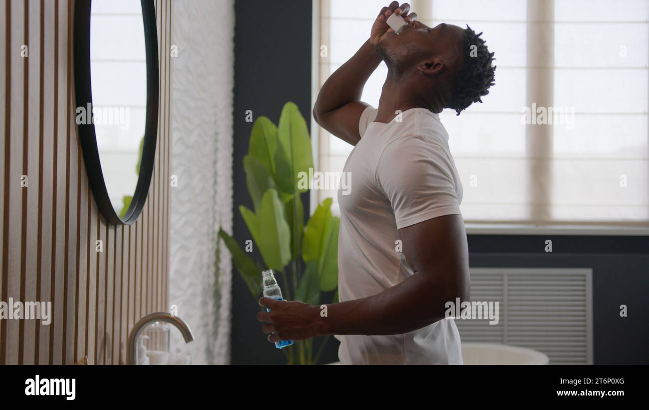 African American man cleaning teeth rinse with dental care product ...