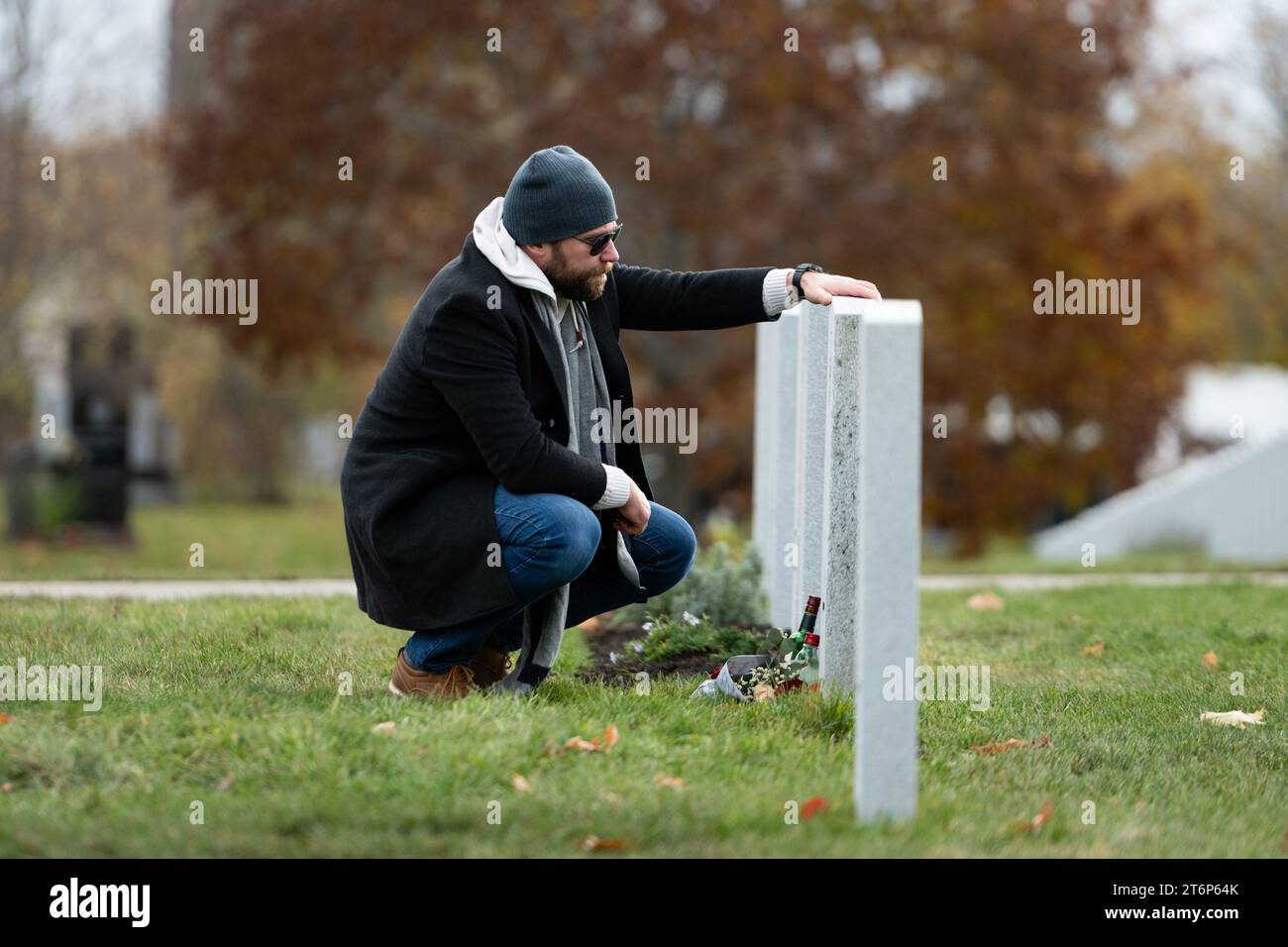 A person, name not provided, touches the tombstone of friend and ...