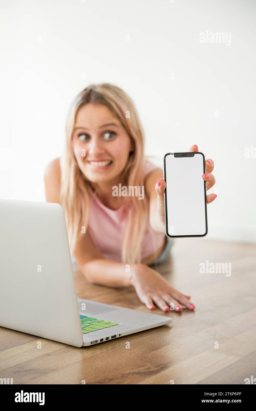 Blonde influencer showing smartphone floor Stock Photo - Alamy