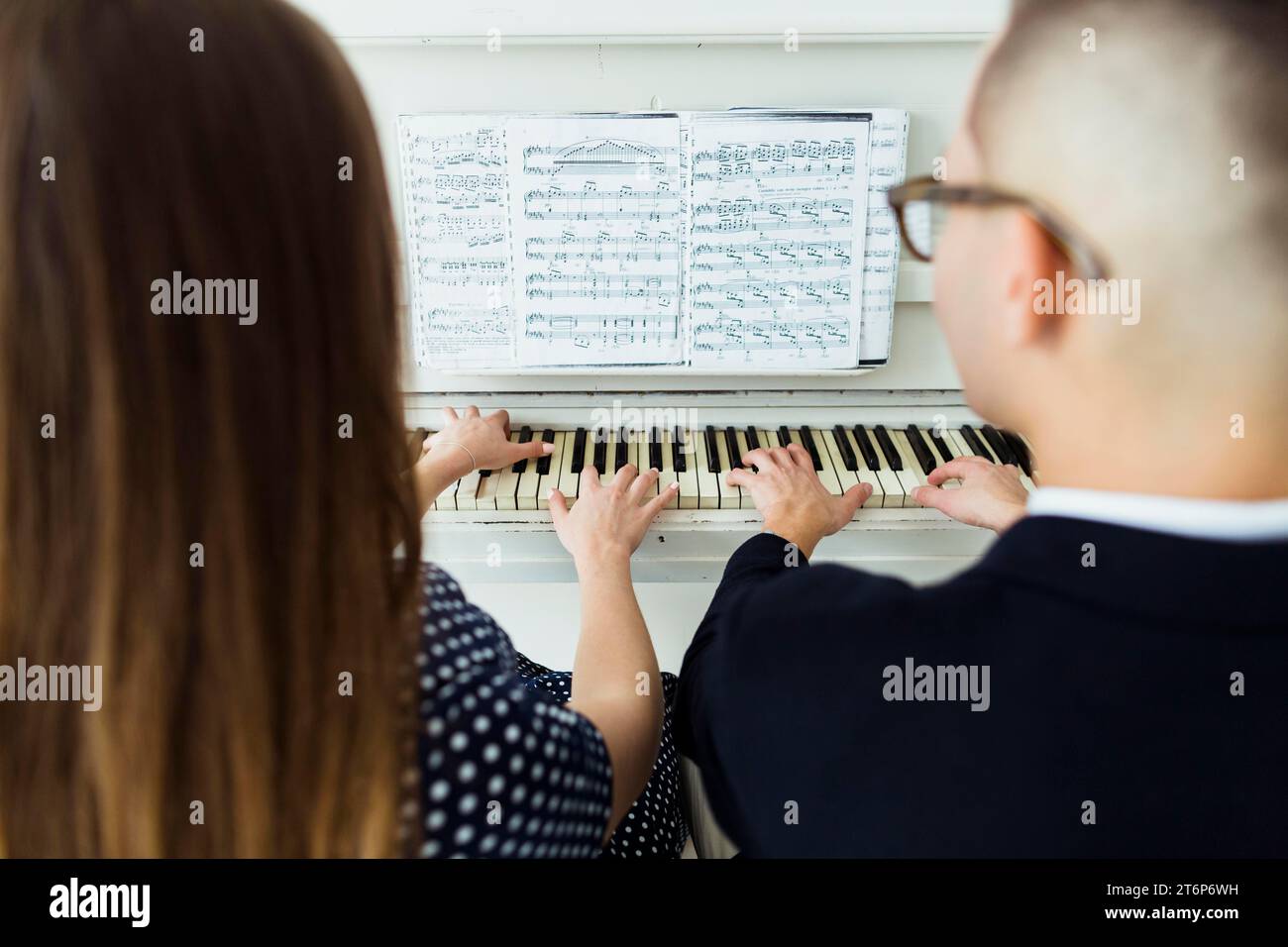 Close up couple playing piano with musical sheet Stock Photo - Alamy