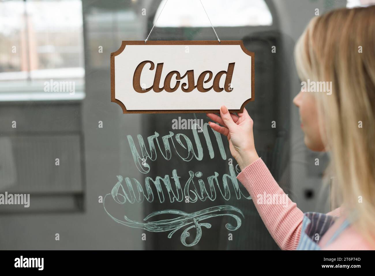 Close up woman looking closed tag hanging glass storefront Stock Photo ...