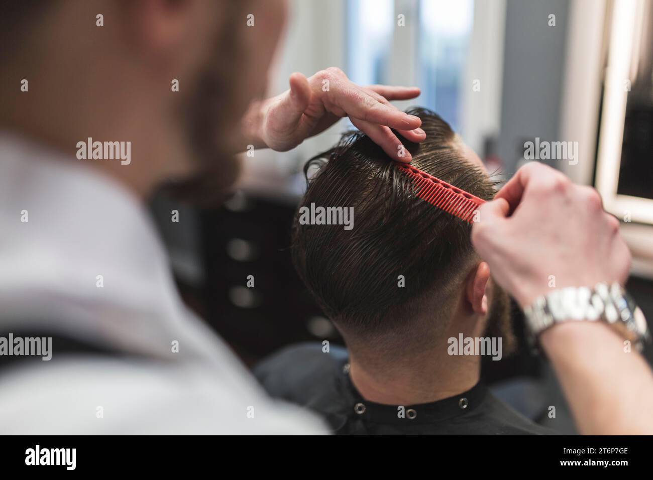 Faceless barber combing hair man before cutting Stock Photo - Alamy
