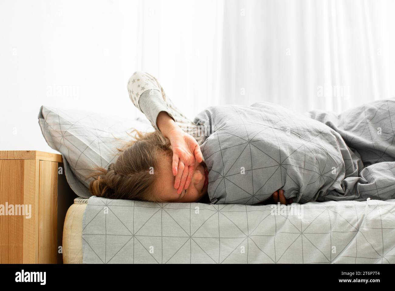 Front view sleeping girl waking up Stock Photo - Alamy