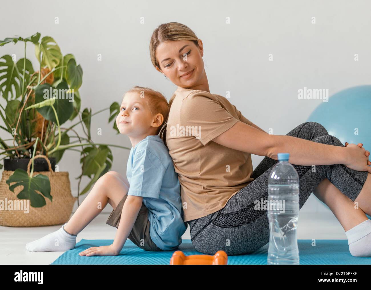 Full shot woman boy sitting mat Stock Photo - Alamy