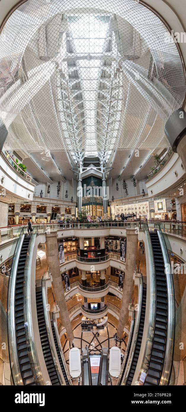 A vertical shot of the interior of a bustling shopping mall, featuring ...