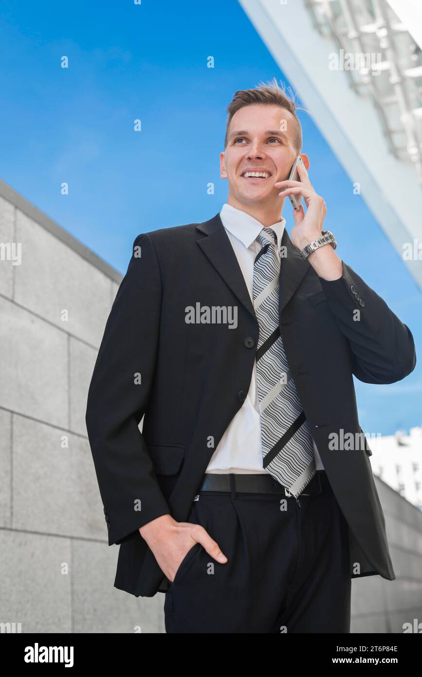 Happy businessman making phone call Stock Photo - Alamy