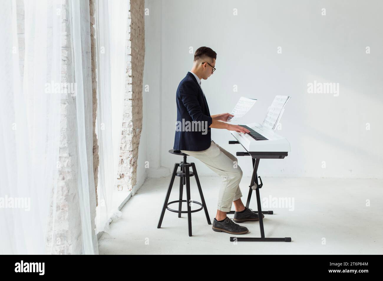 Handsome young man coat looking musical sheet playing keyboard Stock ...