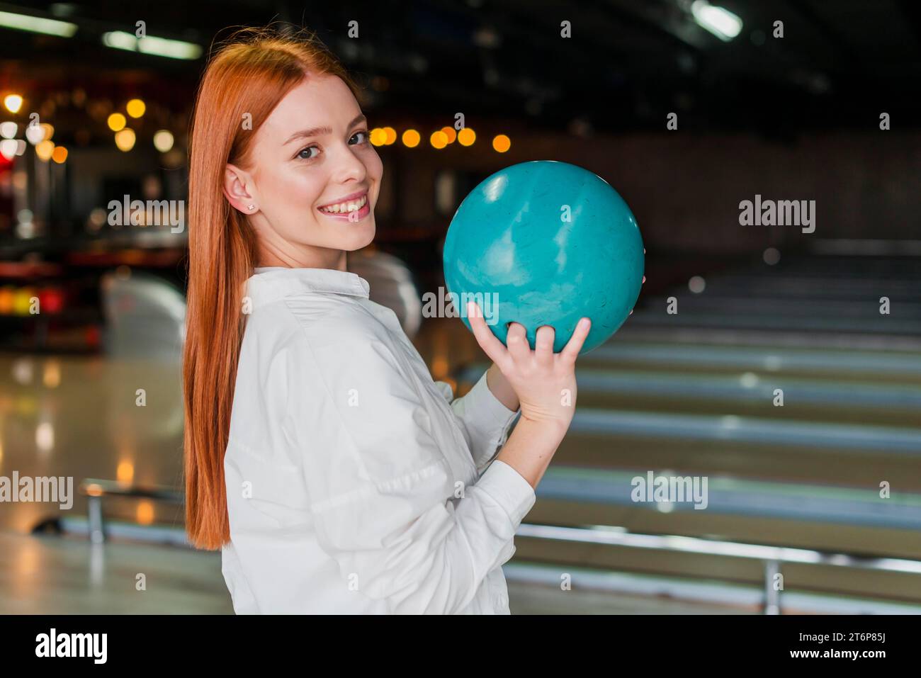 Happy woman holding bowling ball Stock Photo - Alamy