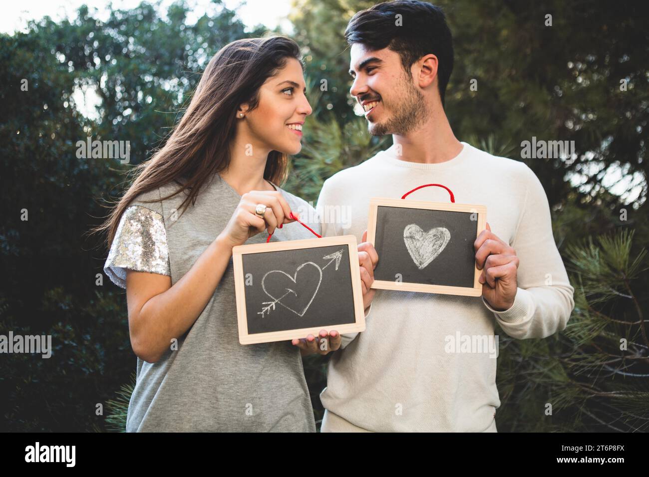 Man woman holding two blackboards with drawn hearts Stock Photo - Alamy