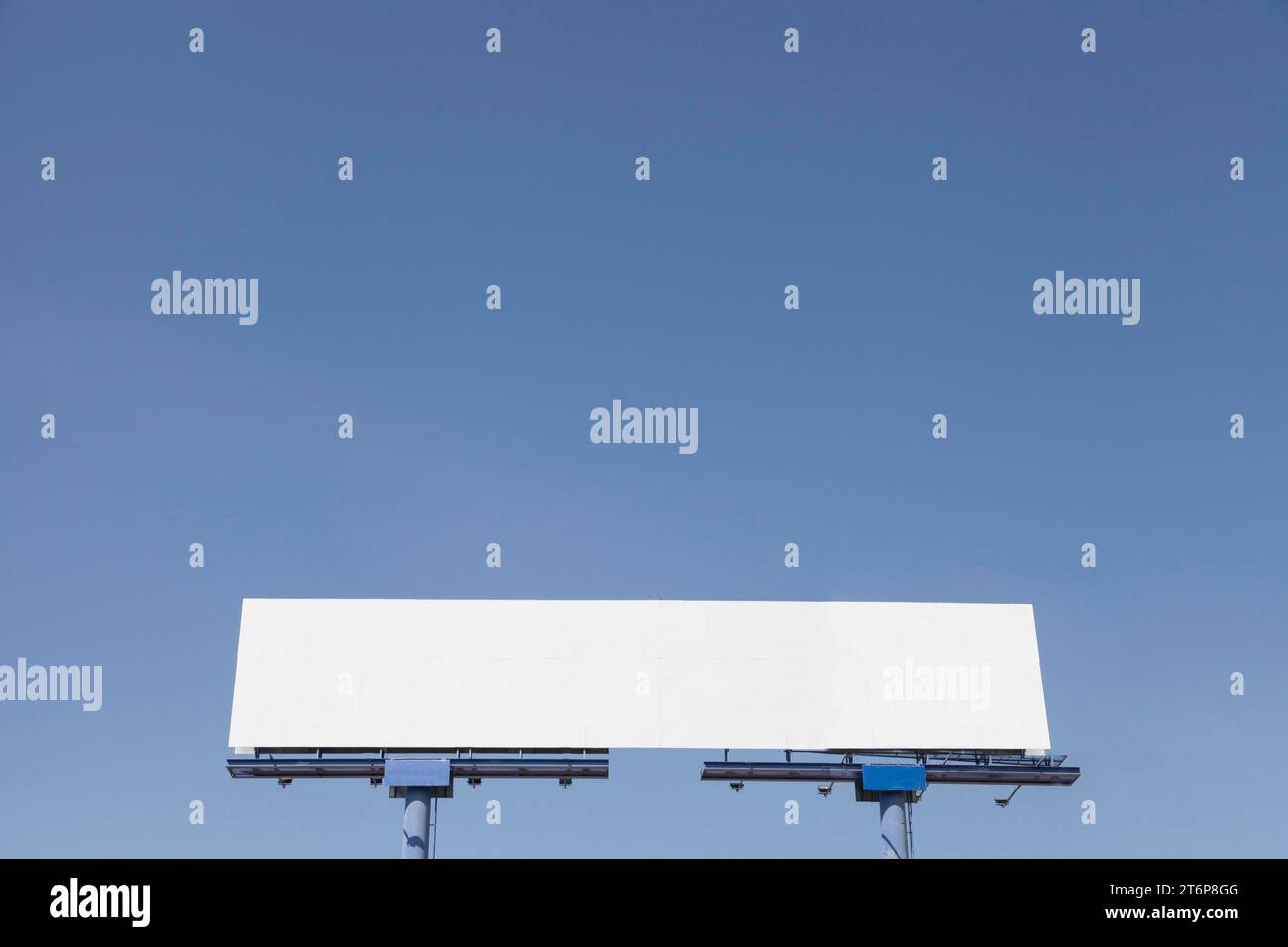 Low angle view advertising billboard against blue clear sky Stock Photo ...