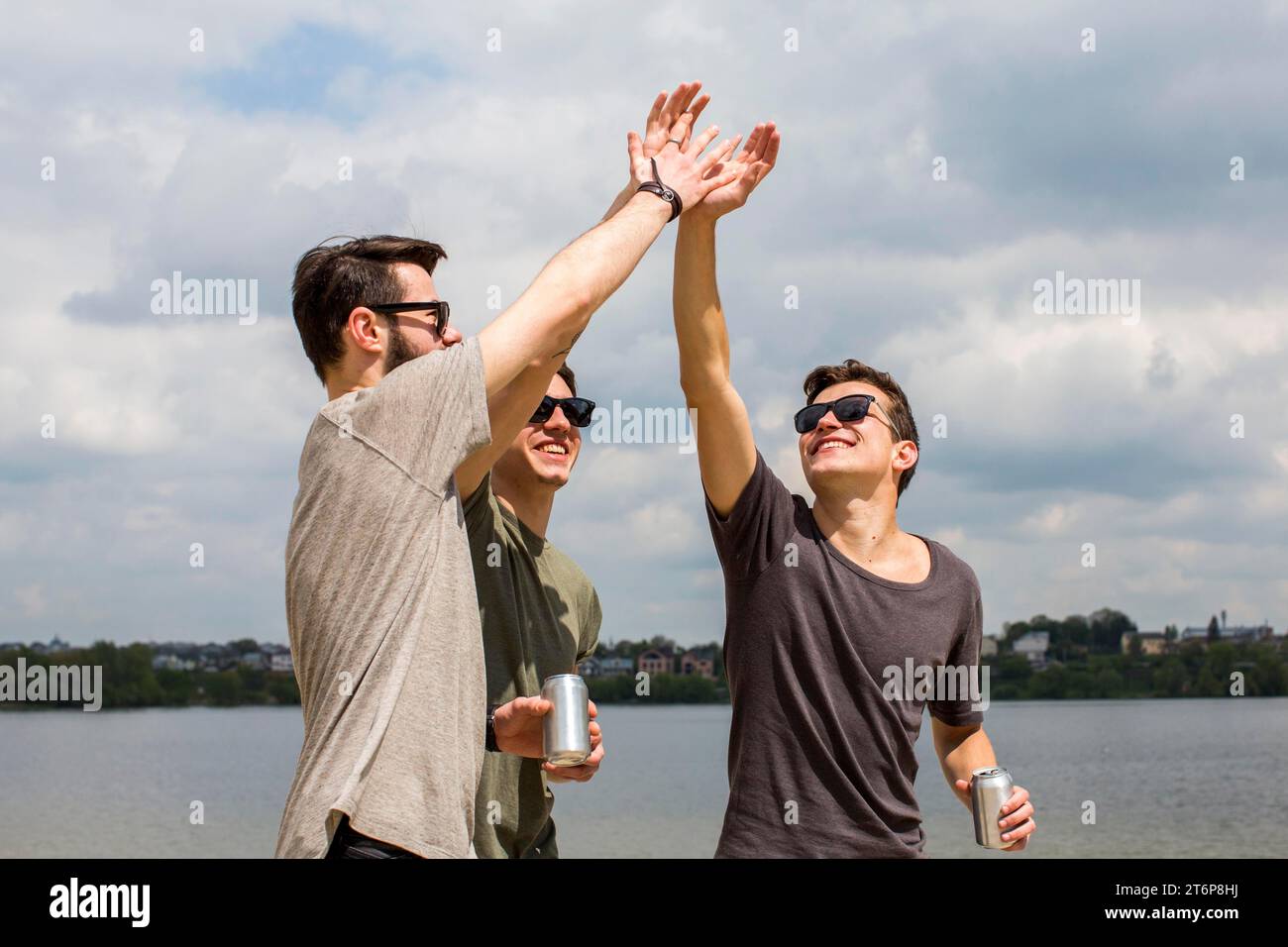 Male friends giving high five Stock Photo - Alamy