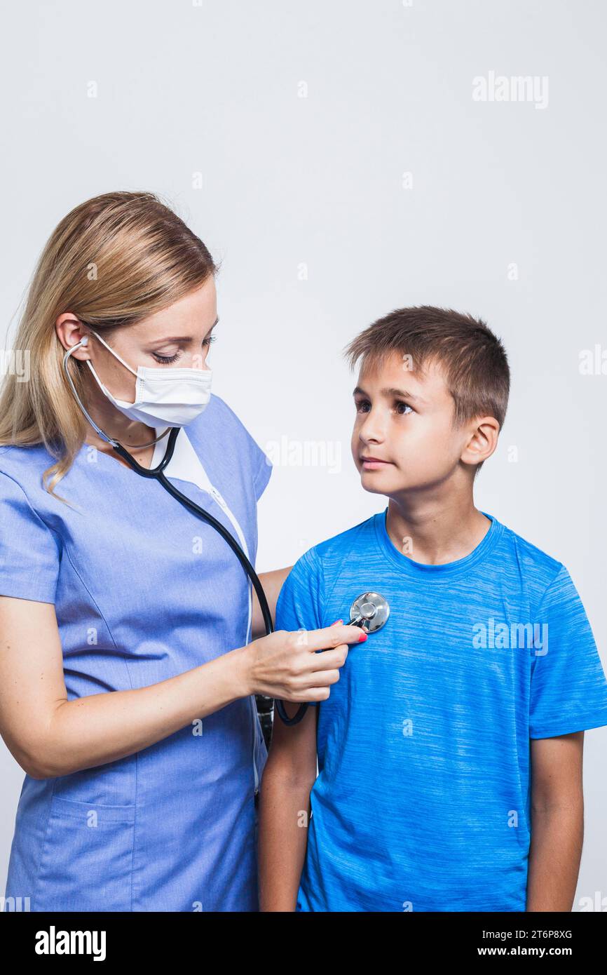 Nurse examining boy with stethoscope Stock Photo - Alamy